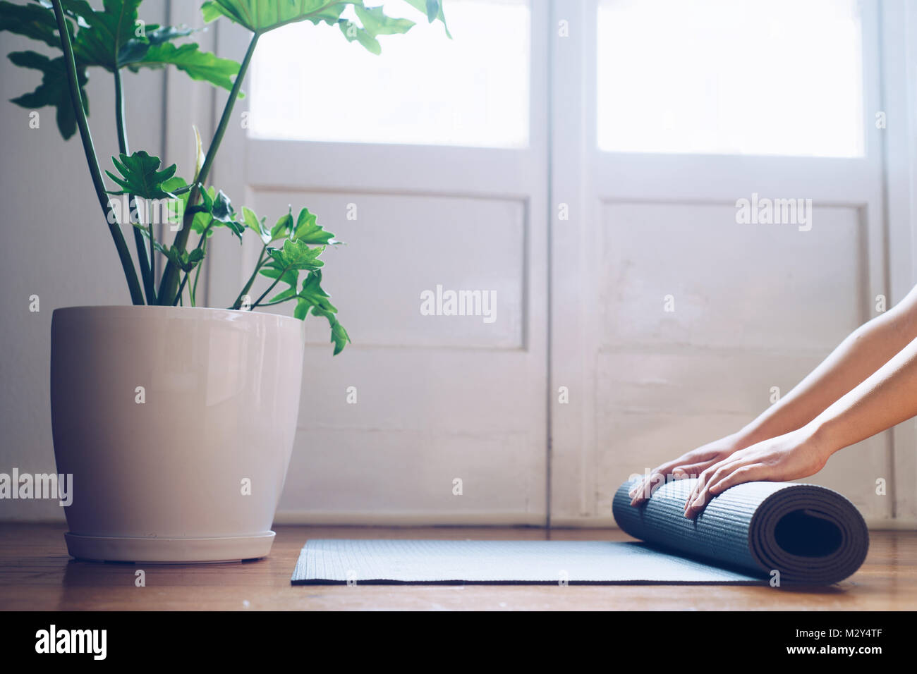 Woman folding yoga mat hi-res stock photography and images - Alamy