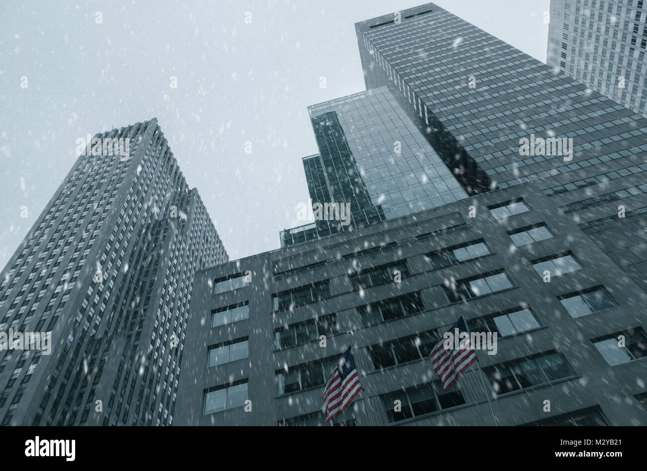 Falling snow in New York City skyline with urban skyscrapers in ...