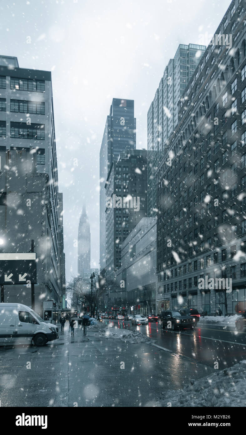 Falling snow in New York City skyline with urban skyscrapers in ...