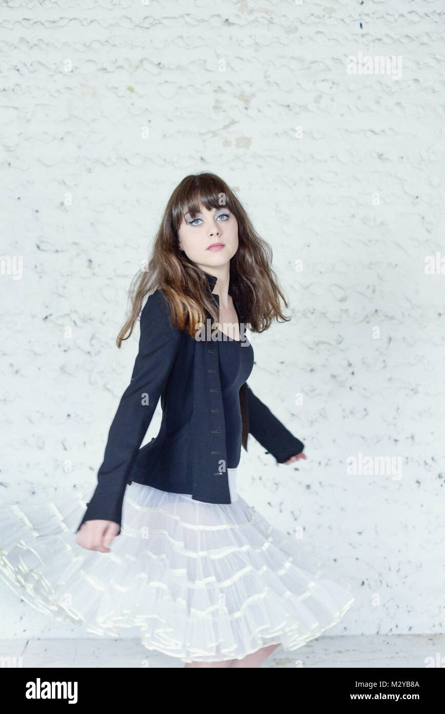 Emotionless Girl moving around a room on a white background, she is ...