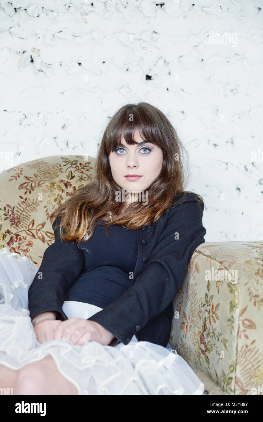 Emotionless Girl moving around a room on a white background, she is ...