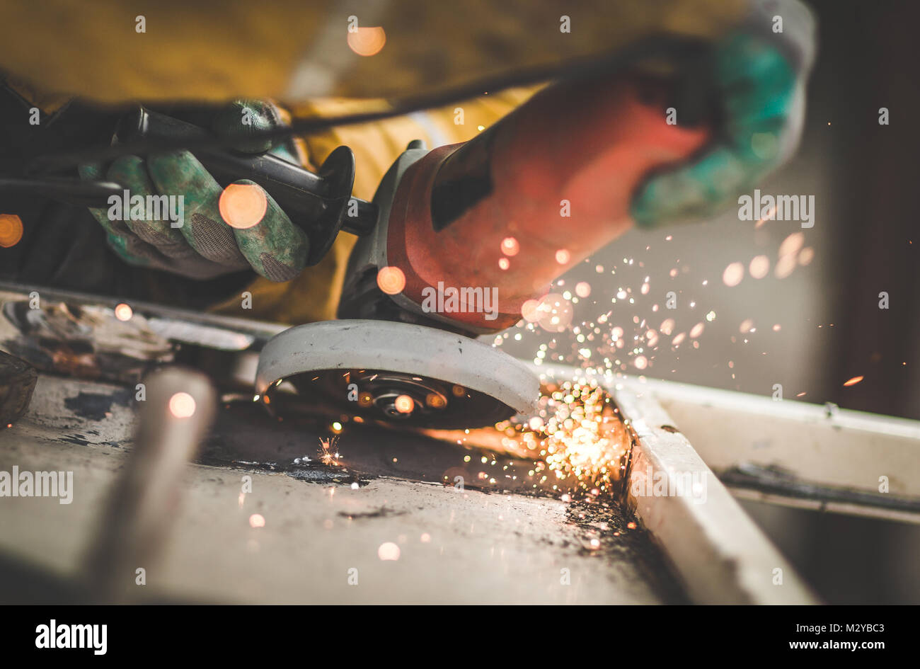 Craftsman sawing metal with disk angle grinder in a warehouse Stock ...