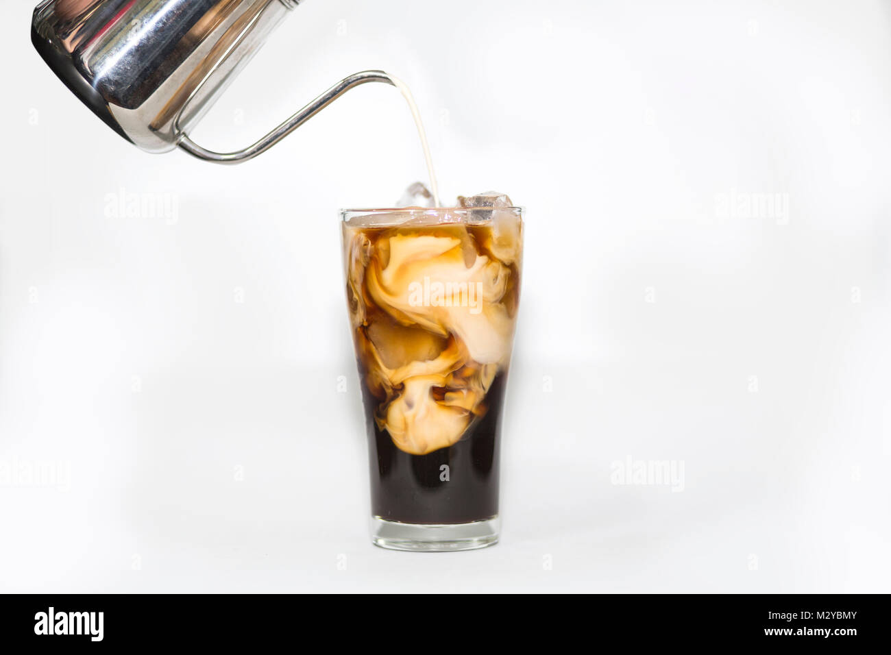 milk pour over glass of ice coffee in white background Stock Photo - Alamy
