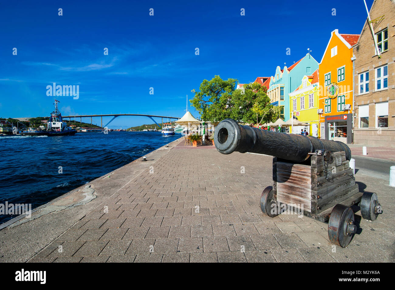 Old cannon before the dutch houses at the Sint Annabaai in Wilemstad ...