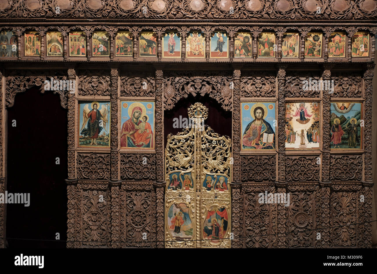 An old wooden iconostasis with icons and religious paintings displayed ...