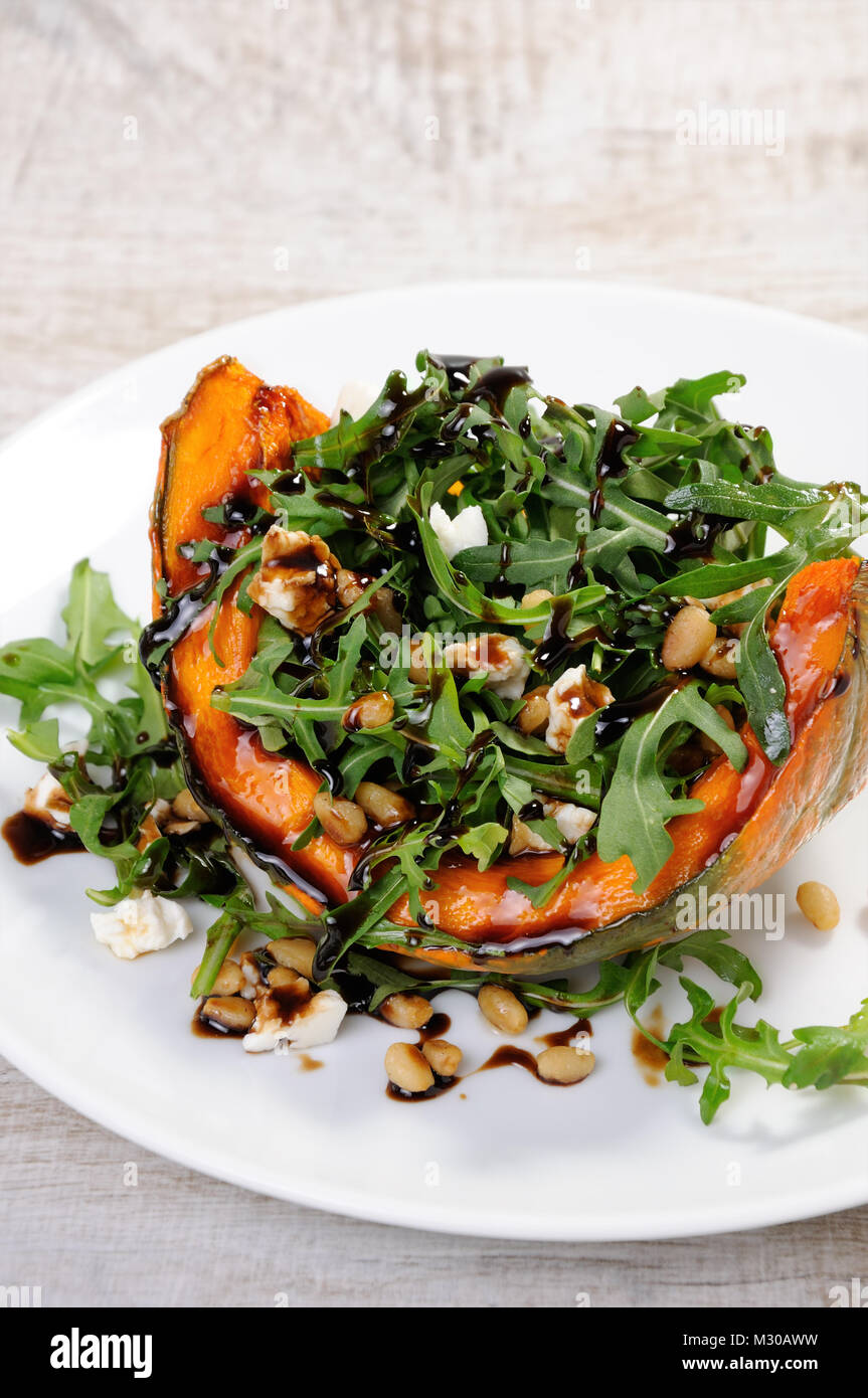 arugula serving on wedges of baked pumpkin seasoned with goat cheese ...