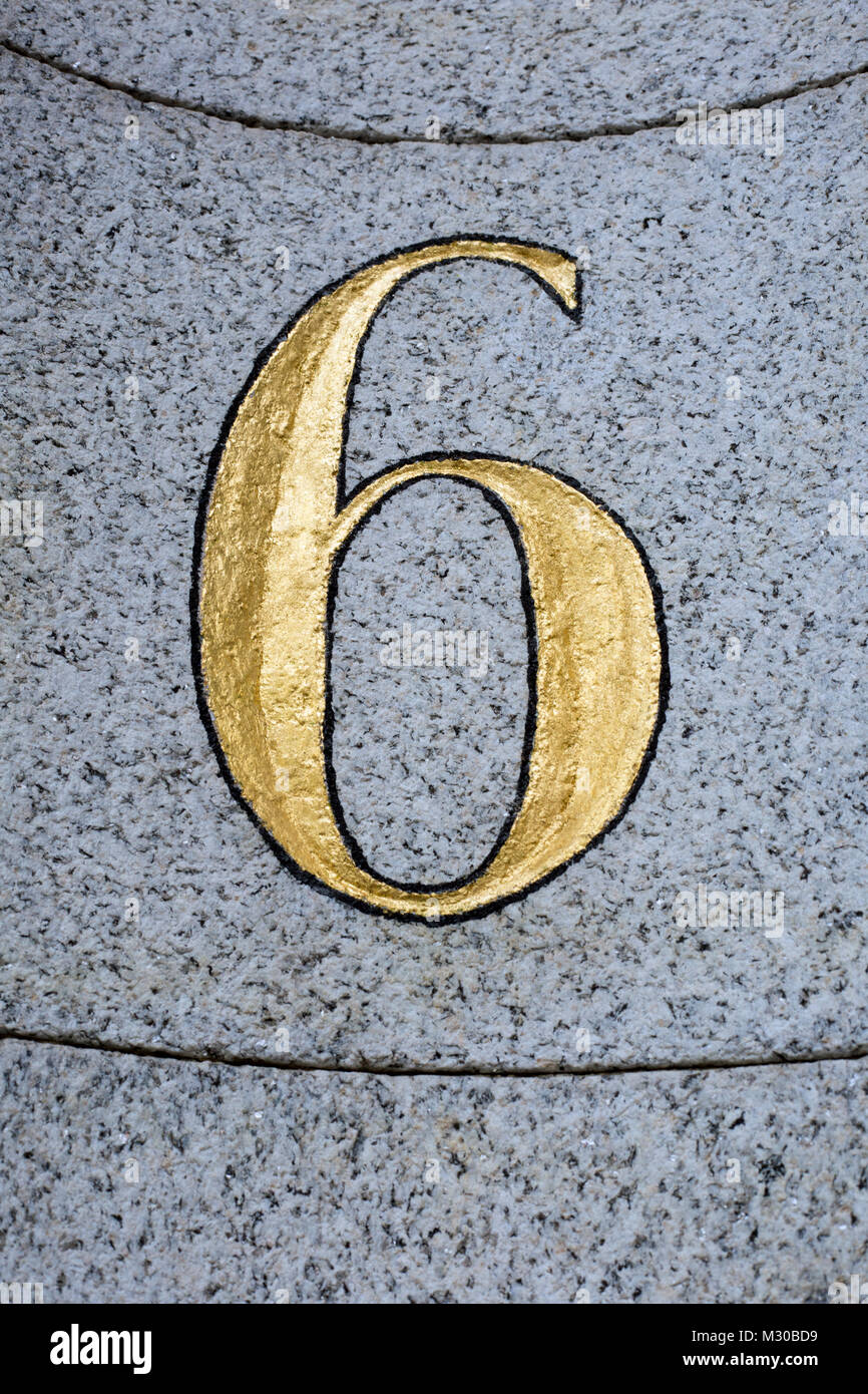 Arabic number six chased in gold gilding and set in a grey granite ...