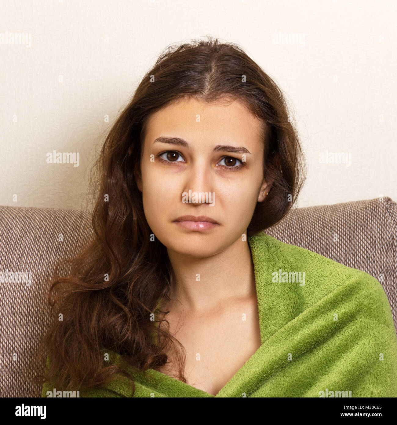 Teens psychological problems. Depressed young woman sitting on sofa ...