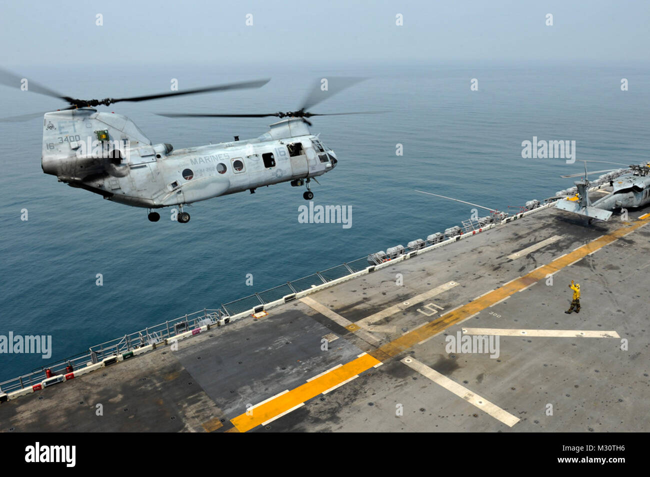 A CH-46 Sea Knight helicopter takes off from the flight deck by #PACOM ...