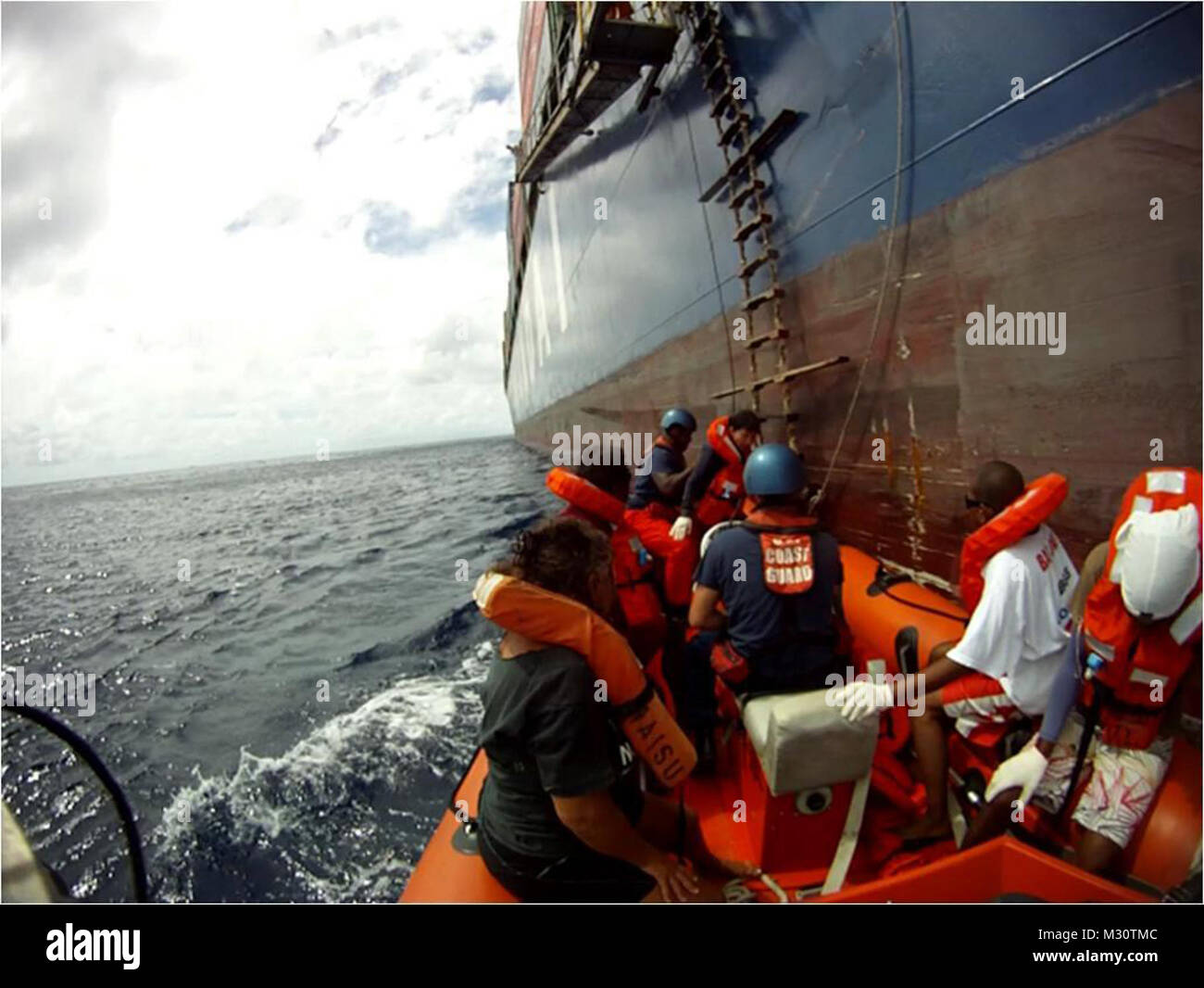 Coast Guardsmen aboard a small boat from the 110-foot Coast Guard ...