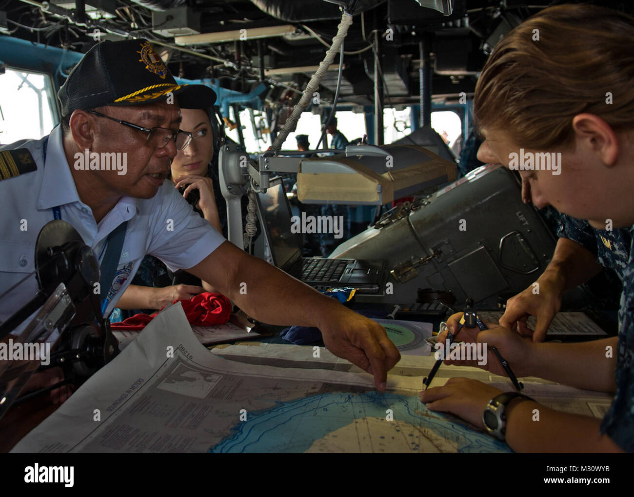 USS Tortuga in plotting a safe passage as the ship transits Manila ...