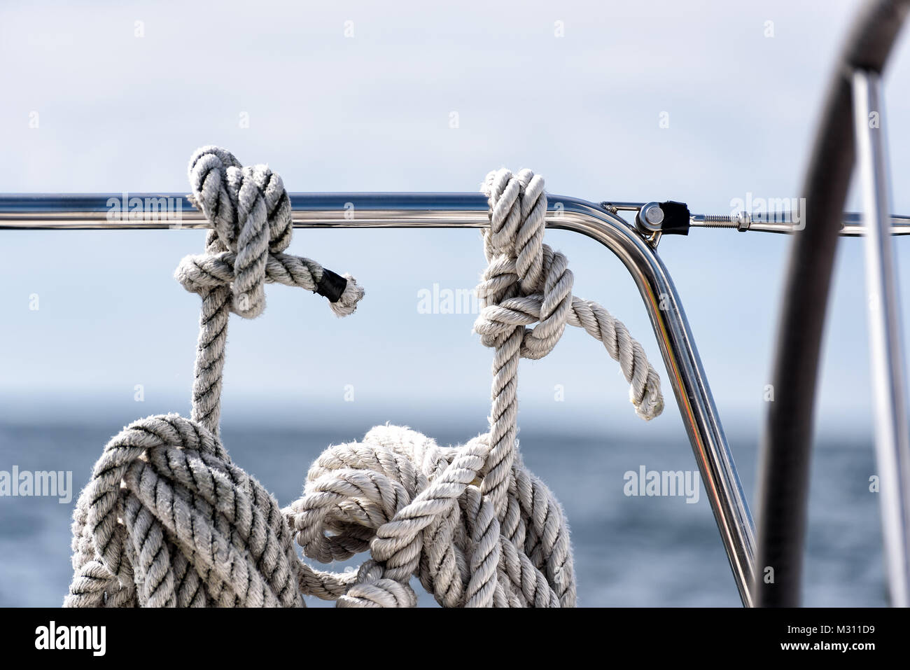 mooring lines hanging on the reeling on a sailing yacht on the ocean ...
