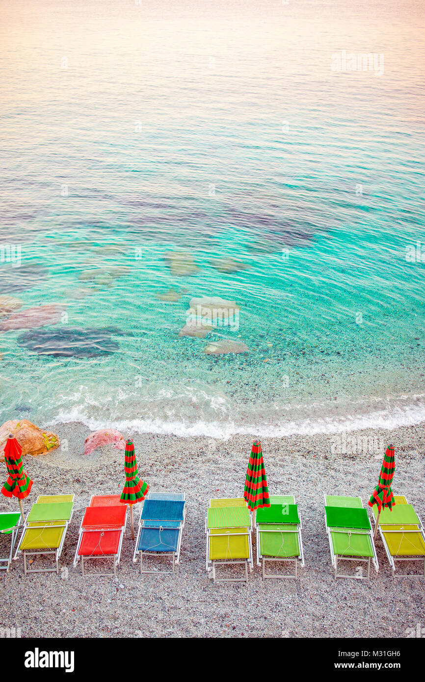 Sunbeds and umbrellas at beautiful european seashore in Monterosso ...