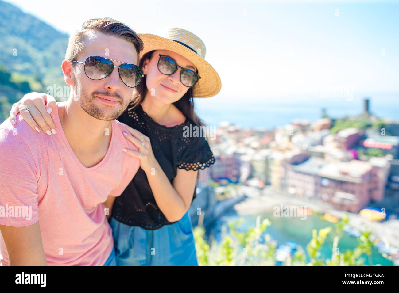 Young couple with view of the old coastal village in Cinque Terre ...