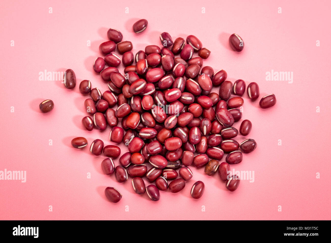 a small pile of Japanese adzuki (aduki, azuki) beans on pink background ...