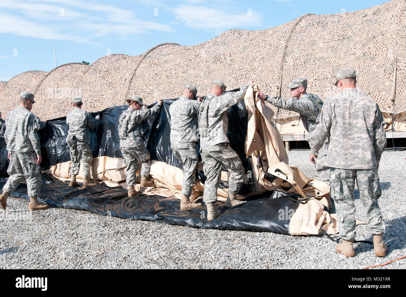 Soldiers of the 542nd Quartermaster Company unfold an air-supported ...