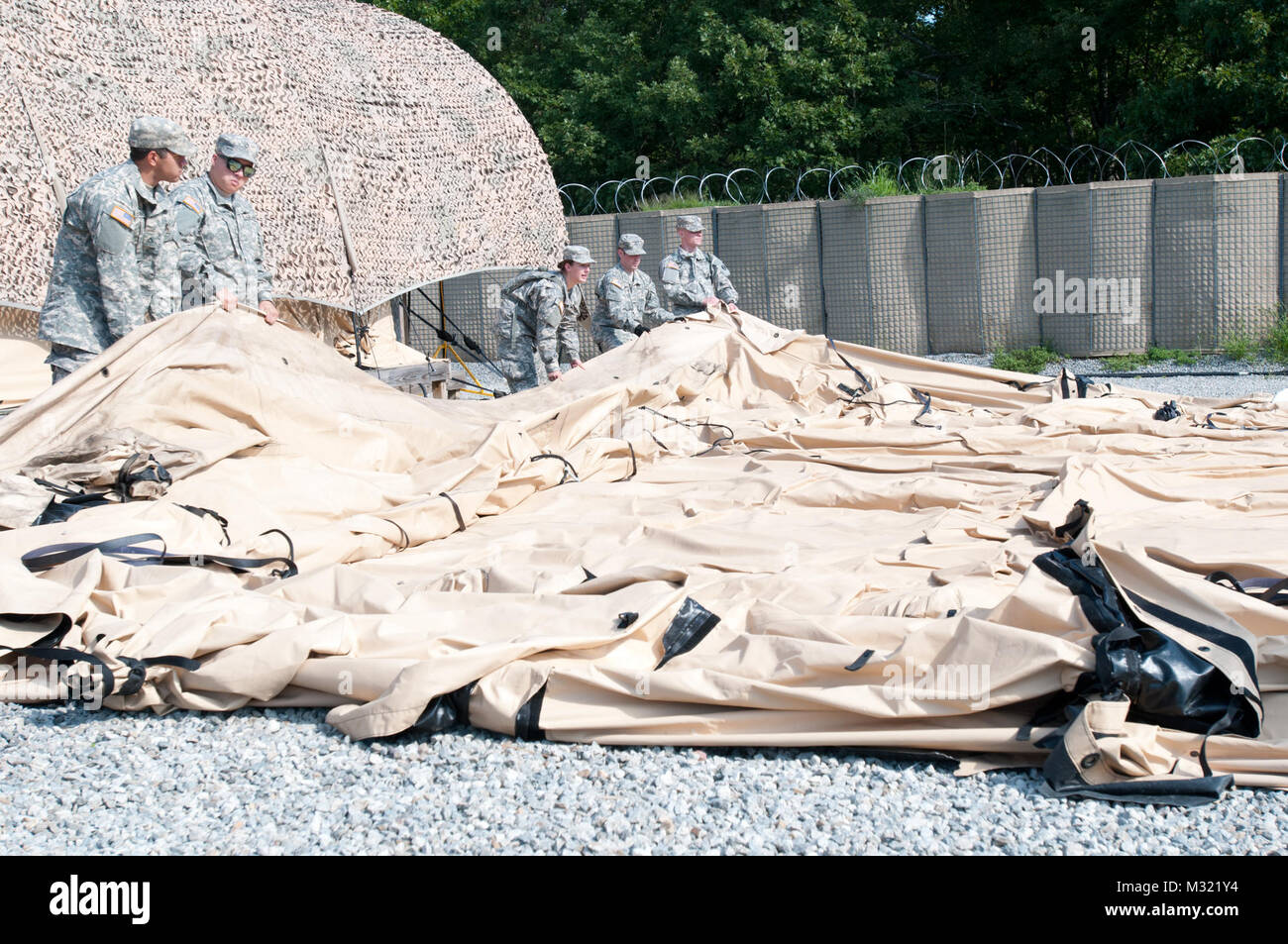 Soldiers of the 542nd Quartermaster Company unfold an air-supported ...