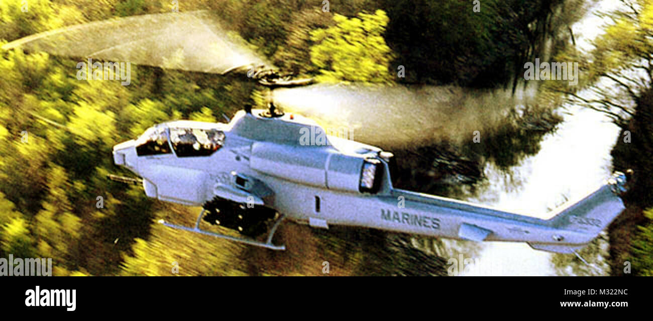 a AH-1W skims along bove the tree tops on a low-level mission to the ...