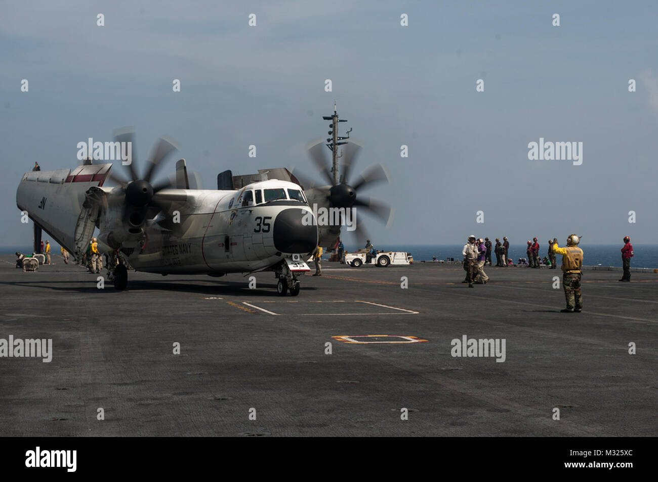 An aircraft handler directs a C-2A Greyhound by #PACOM Stock Photo - Alamy