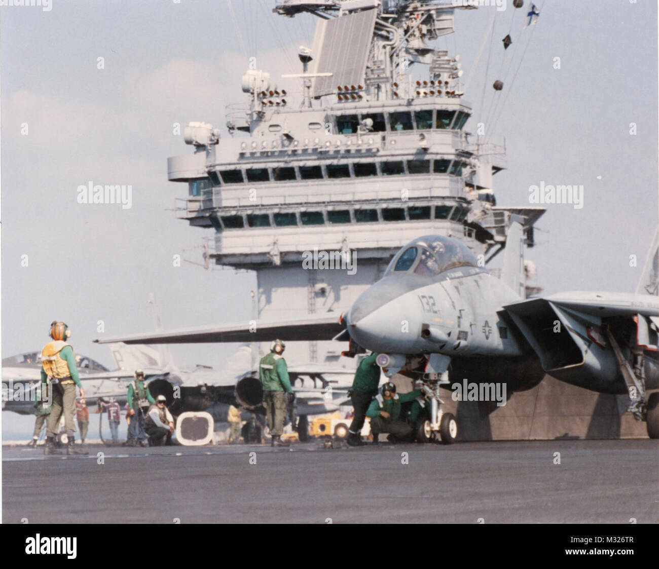 an f-14 is getting the final check as it makes its way to the catapult ...