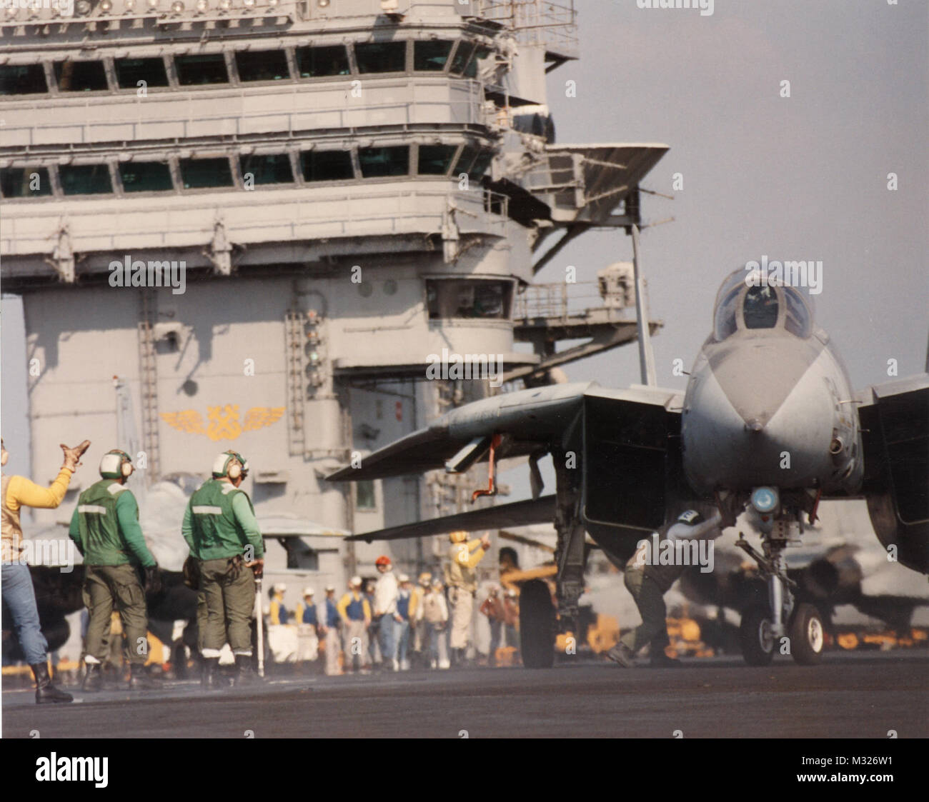 an f-14 is getting the final check as it makes its way to the catapult ...