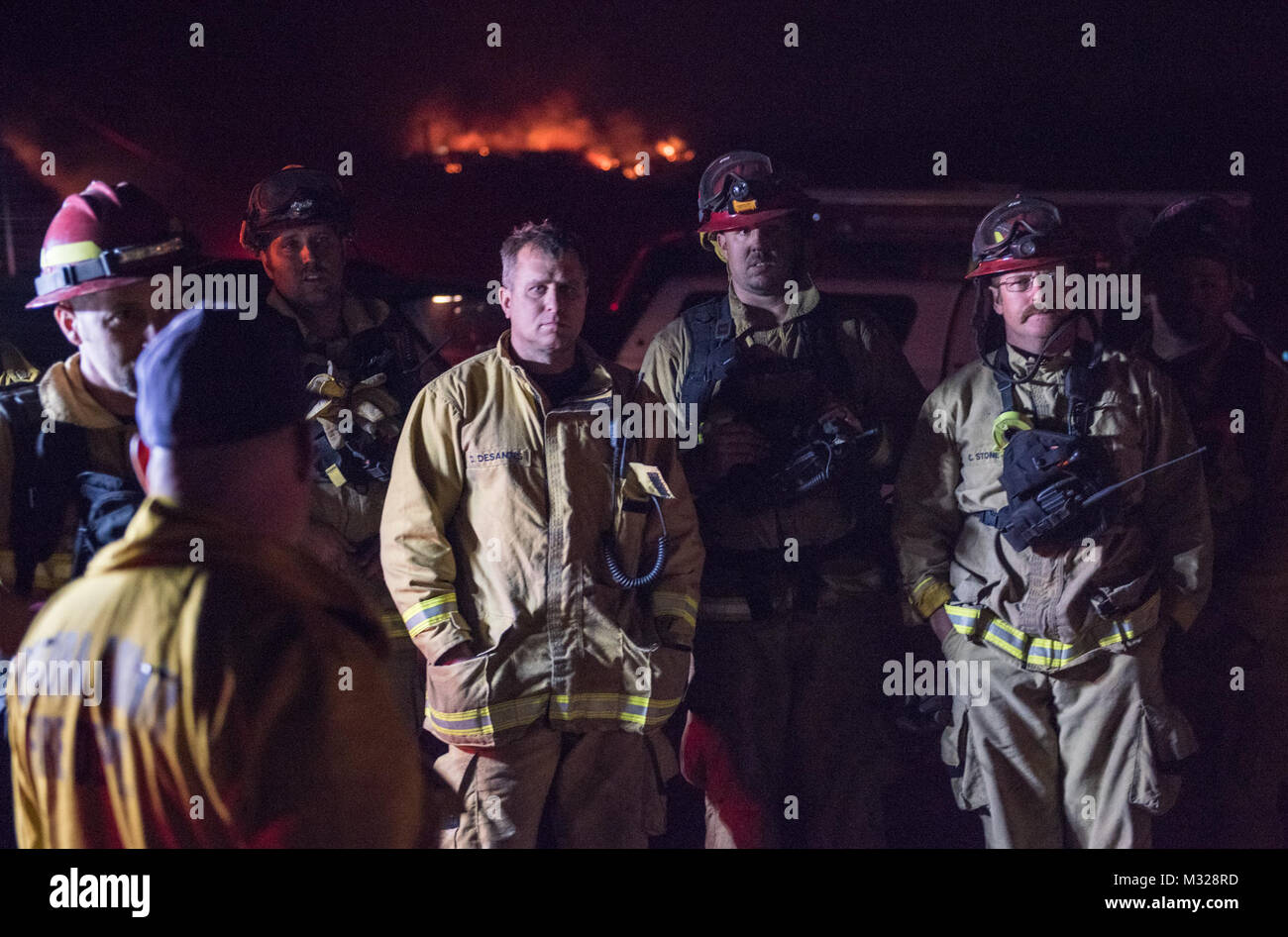 Firefighters assemble before performing a controlled burn to starve the ...