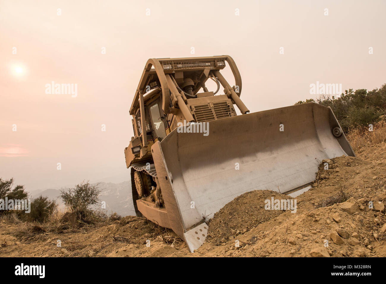 A bulldozer clears a Thomas Fire fire line near Santa Barbara ...