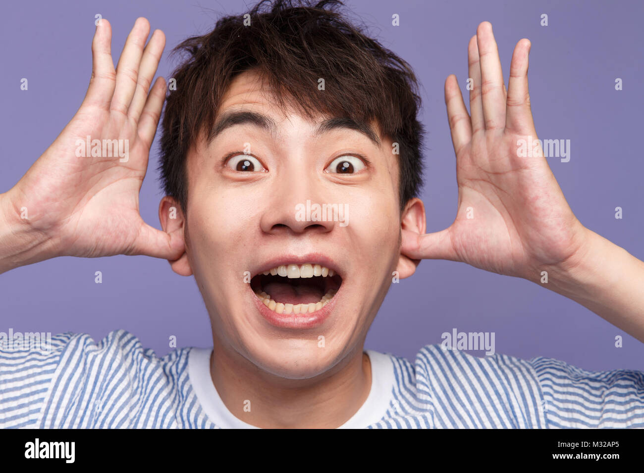 The young man screaming covering her ears Stock Photo - Alamy