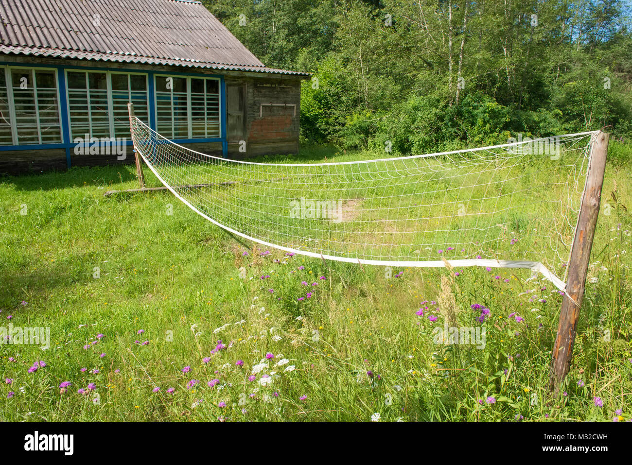 Village volleyball field with overgrown grass and sagging grid Stock ...