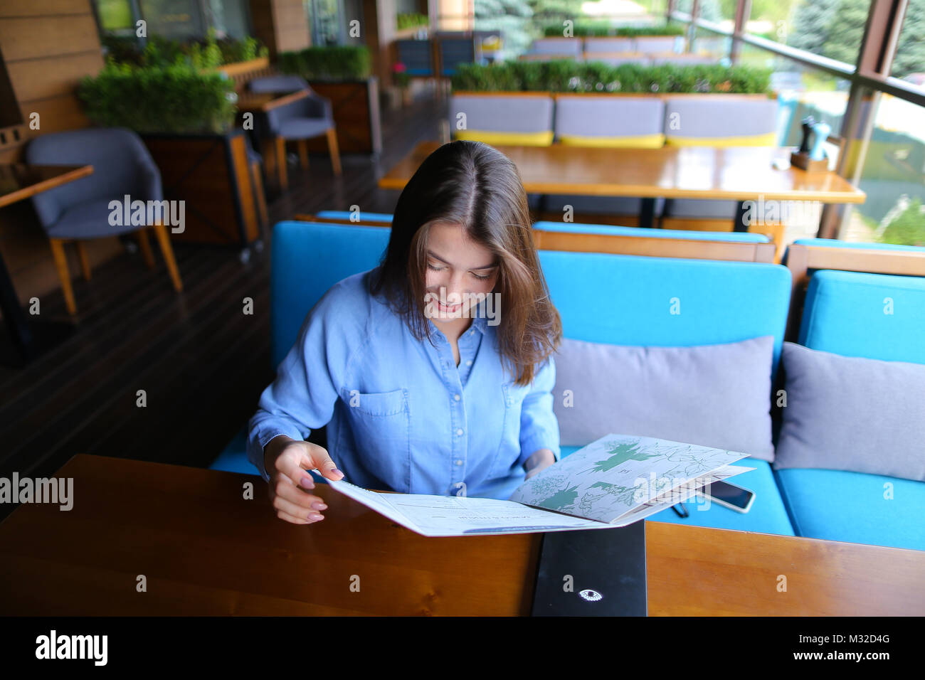 Pretty woman reading menu at restaurant with close up face Stock Photo ...