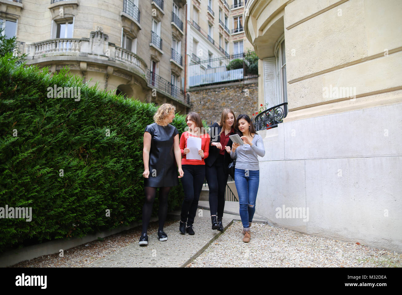 Happy female students talking outside in near university build Stock ...