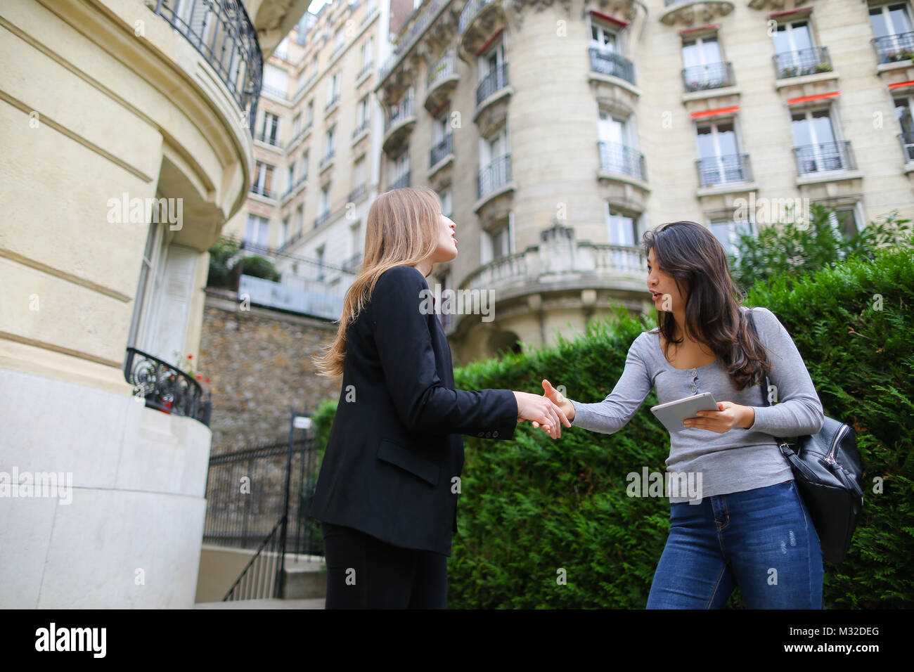 Beautiful girl talking with foreign Chinese student keeping tabl Stock ...