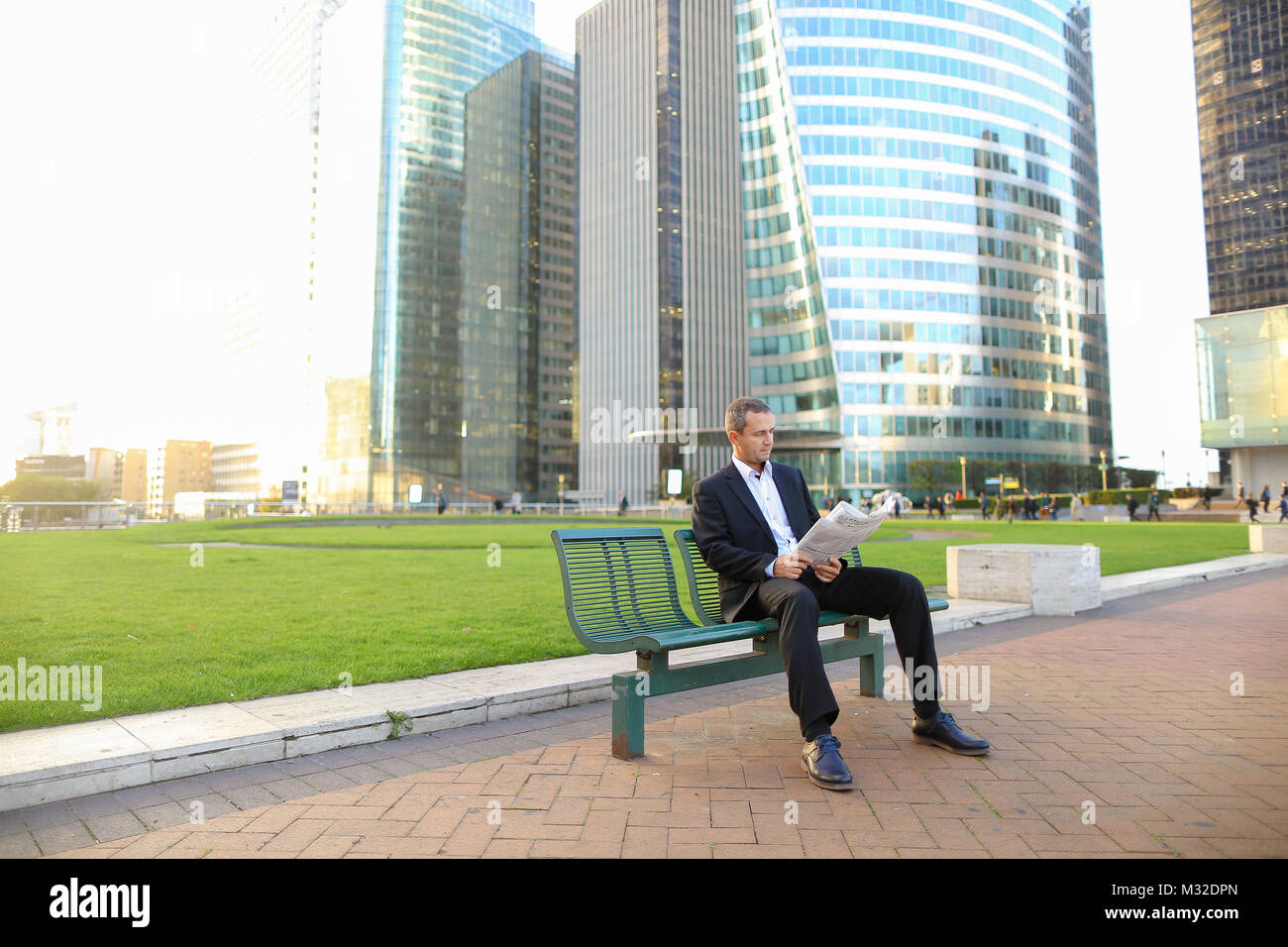 Gladden male manager reading newspaper outside in Stock Photo - Alamy