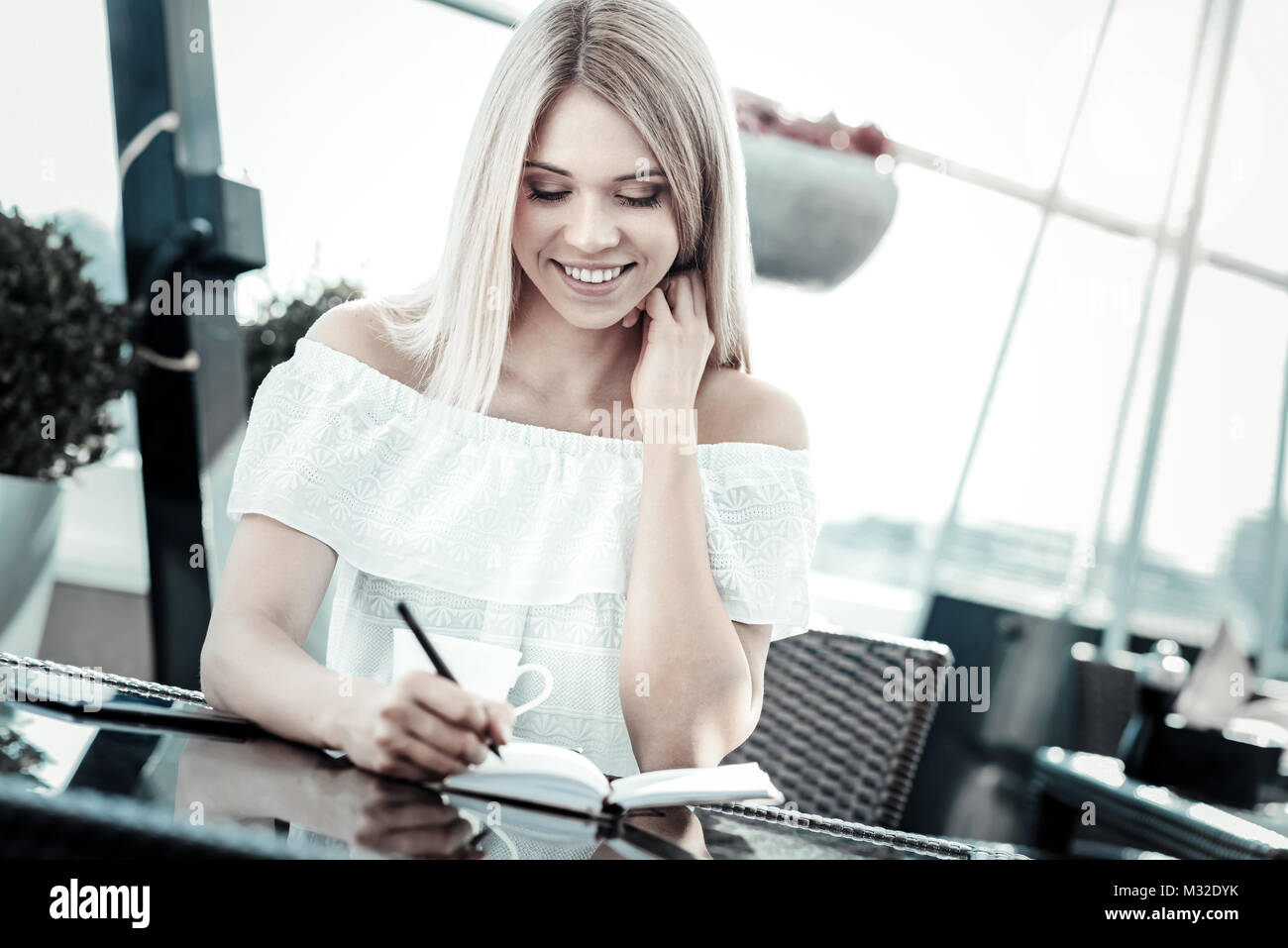 Nice positive businesswoman taking notes Stock Photo - Alamy