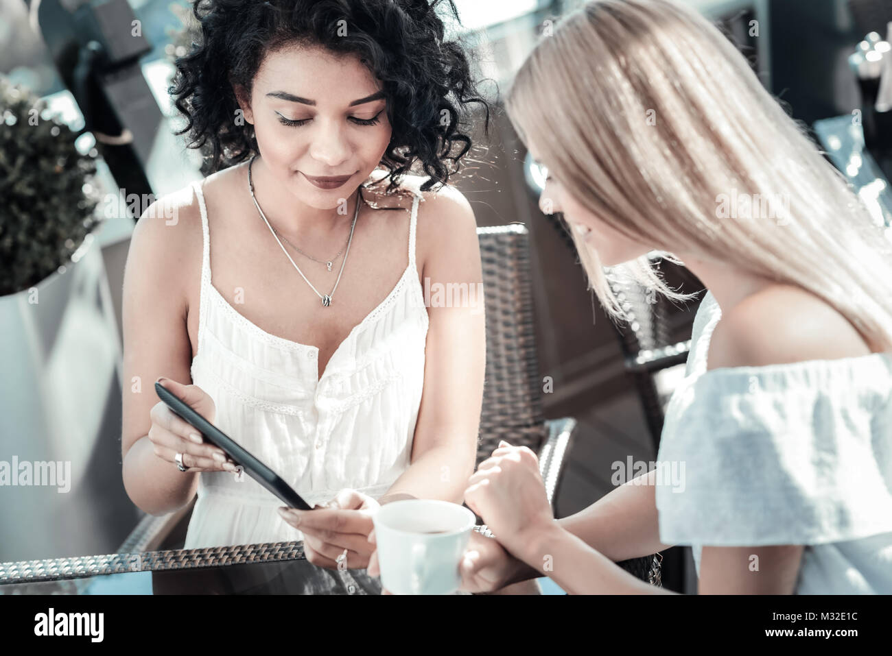 Attractive nice women looking at the tablet screen Stock Photo - Alamy