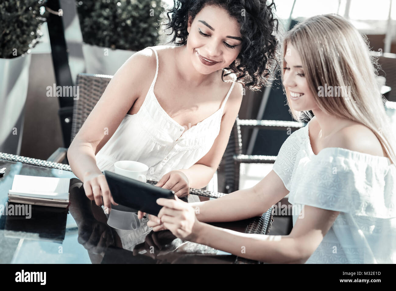 Happy beautiful women using a tablet Stock Photo - Alamy