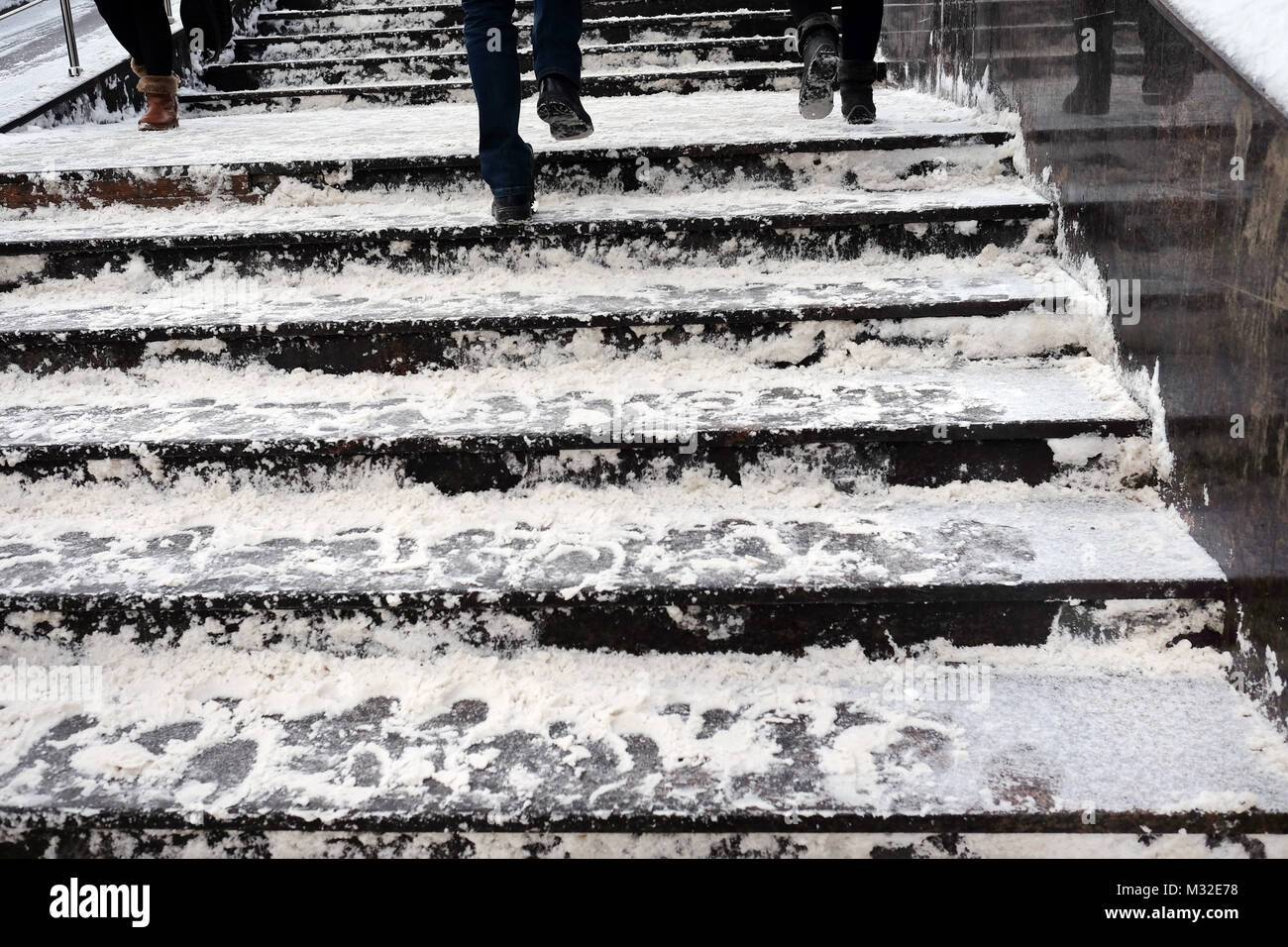 People walking up and down the slippery stairs, outside cropped shot ...