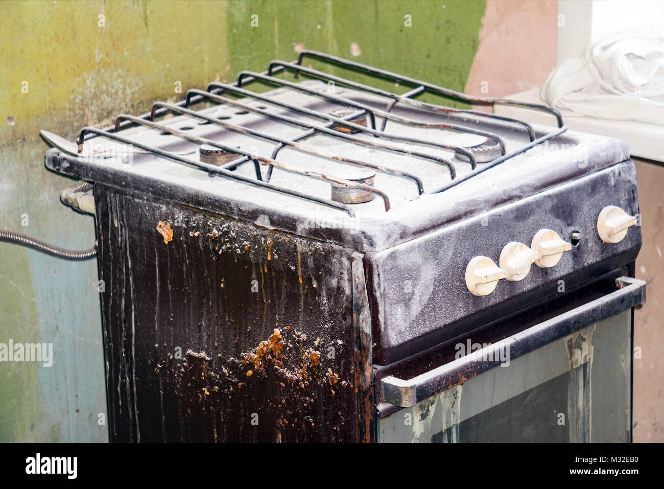 An old dirty gas stove in an abandoned state. Unsanitary conditions ...