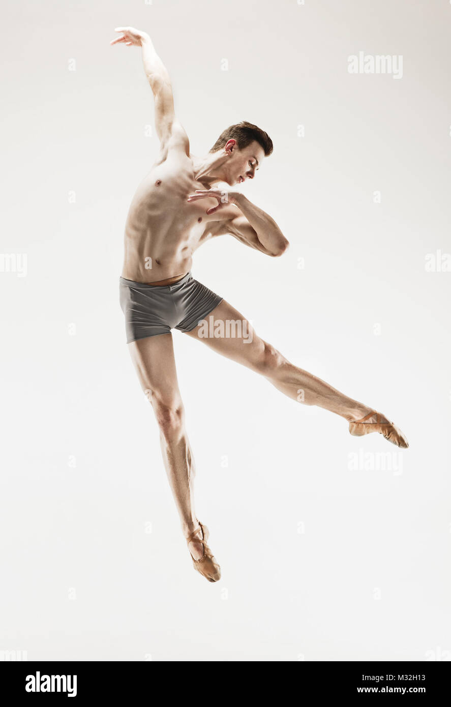 The male athletic ballet dancer performing dance isolated on white ...