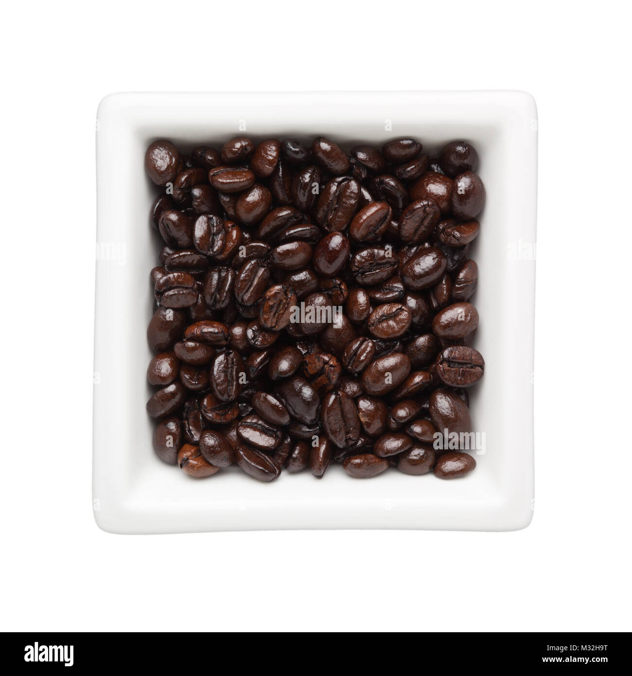 Roasted coffee beans in a square bowl isolated on white background ...