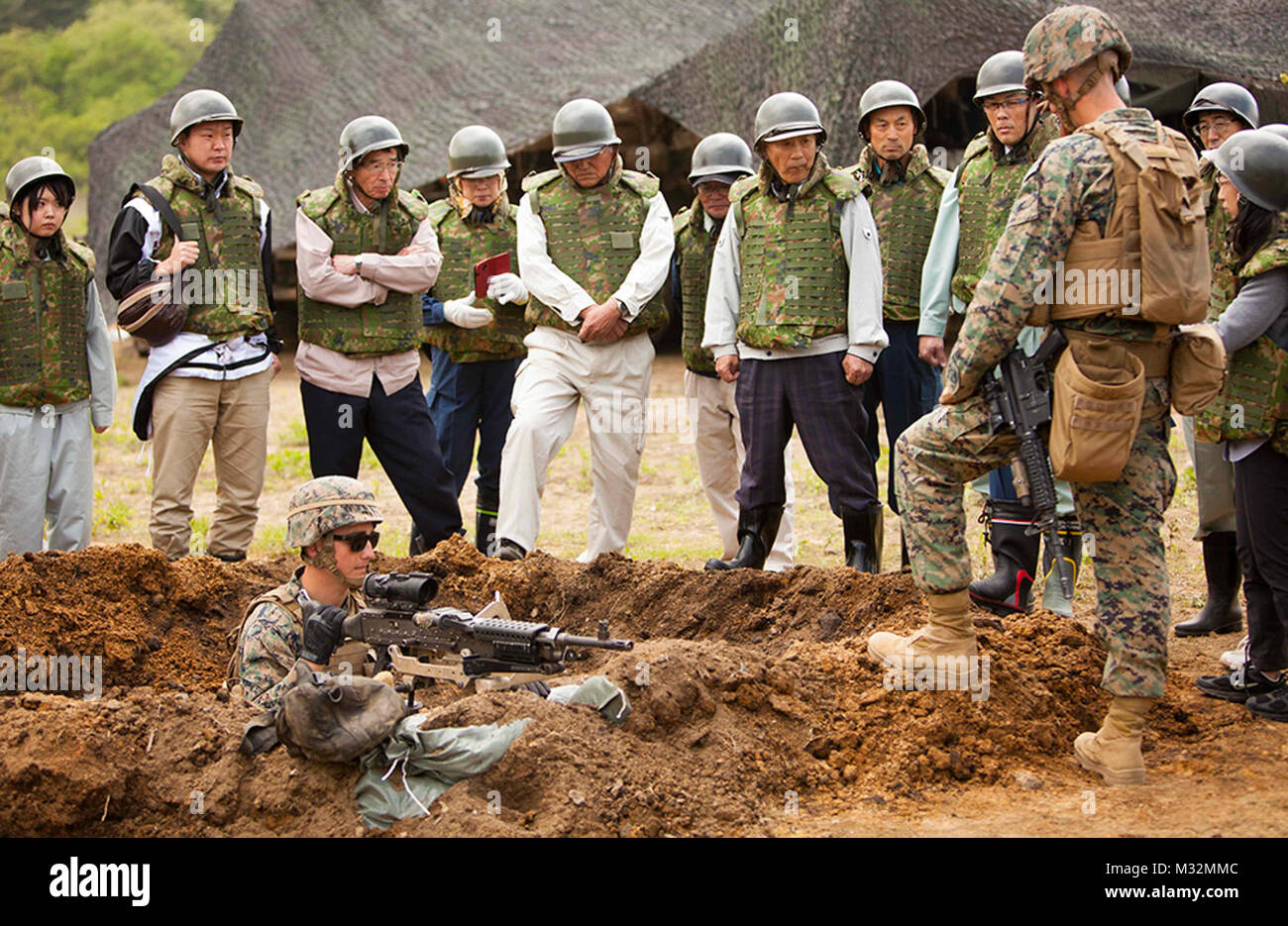 Japanese citizens learn about small arms training during an artillery ...