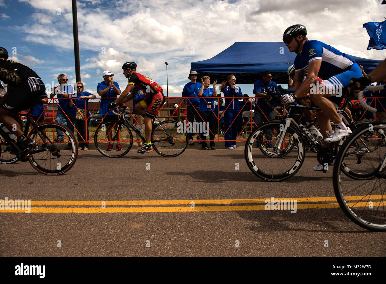 Fans cheer as cyclist at the Men's Open cycling event pass by during ...