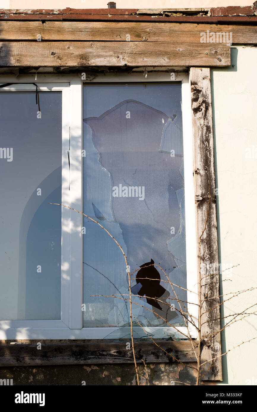 A broken window in an old abandoned building. Broken glass on the ...