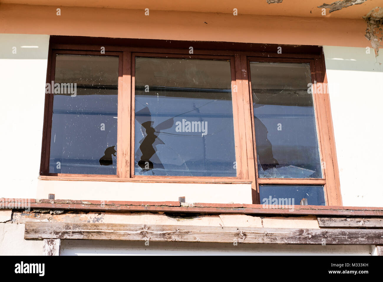 A broken window in an old abandoned building. Broken glass on the ...