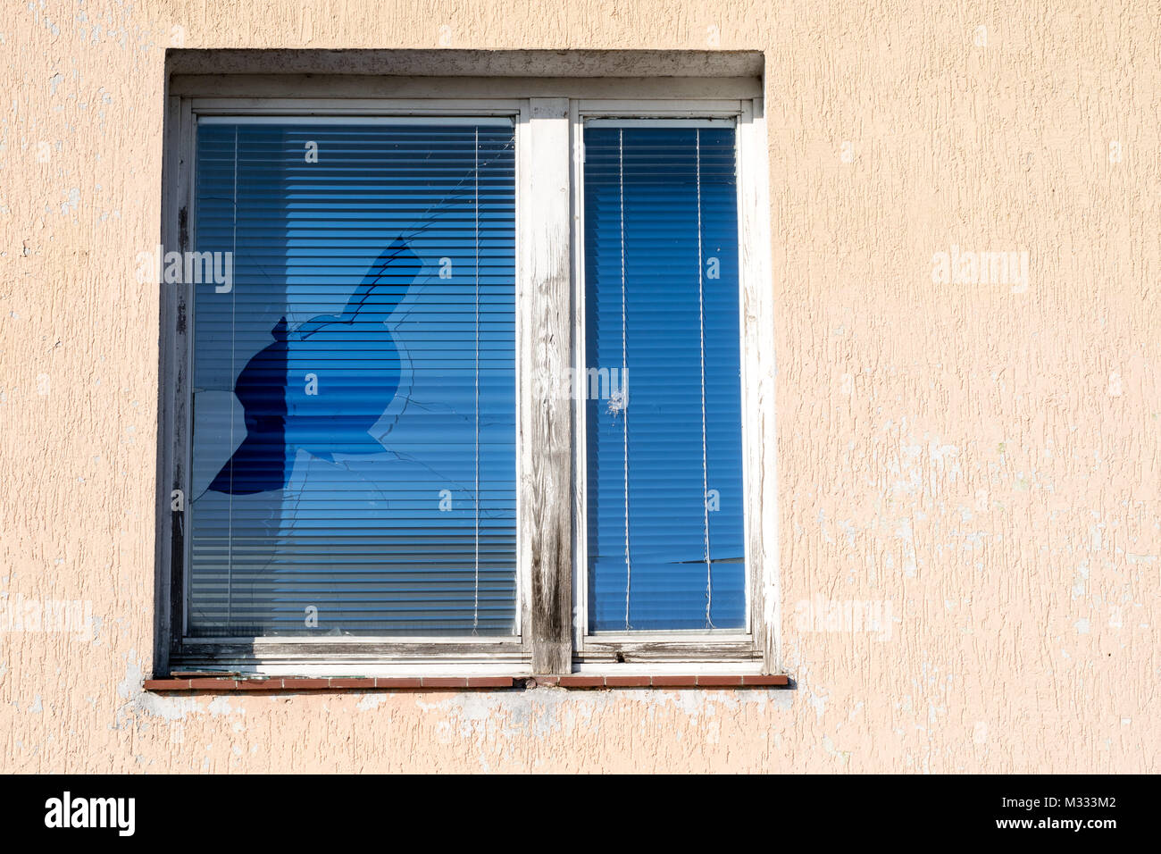 A broken window in an old abandoned building. Broken glass on the ...