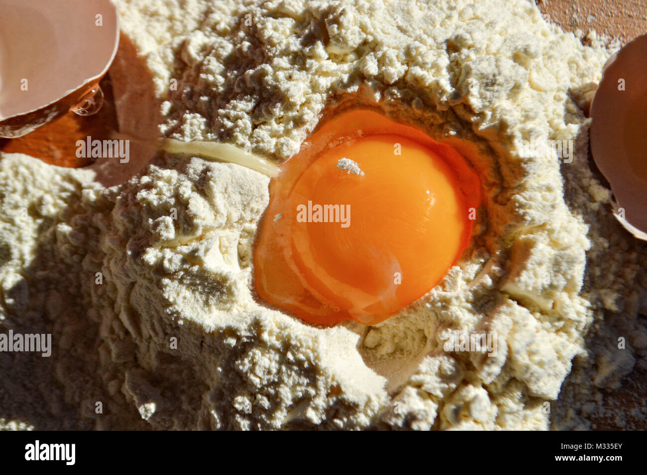 Closeup still life food photography/ Broken egg in the flour on the ...