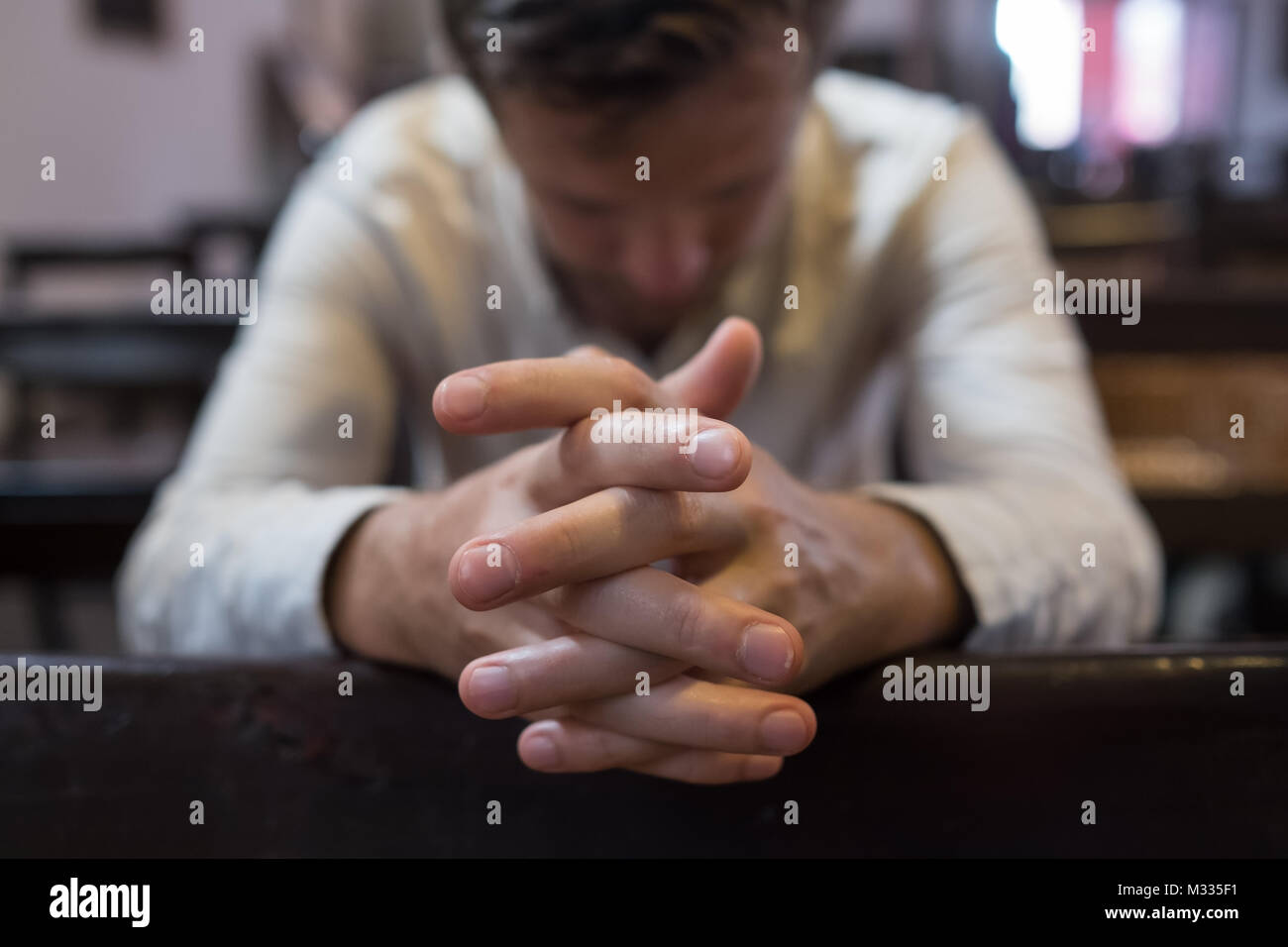 caucasian man praying in church. He has problems and ask God for help ...