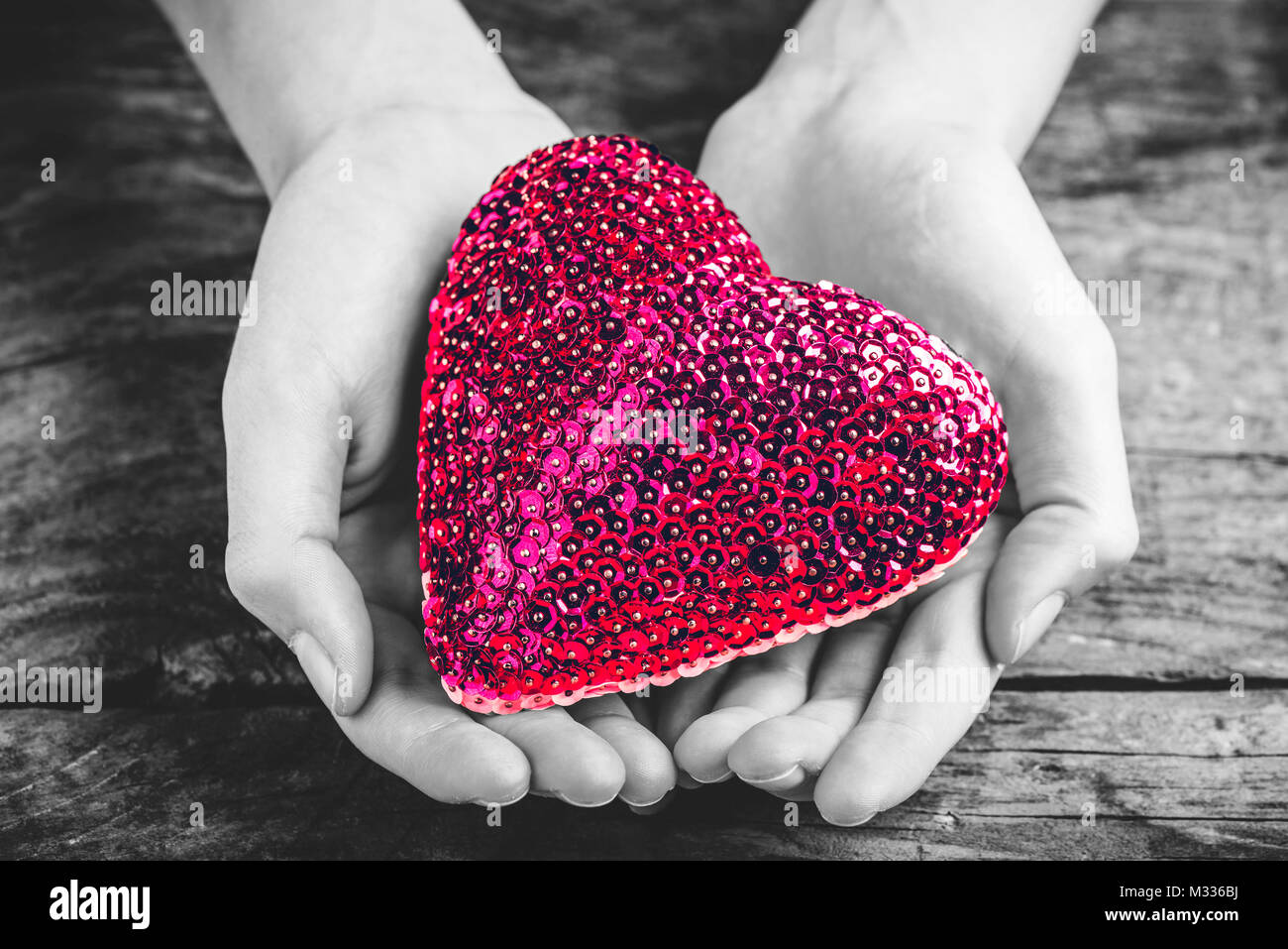 hot red heart in hands over black and white background - love concept ...