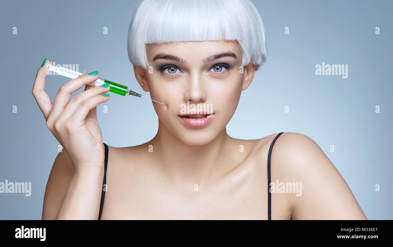 Beautiful woman receiving botox injection in cheek. Portrait of woman ...