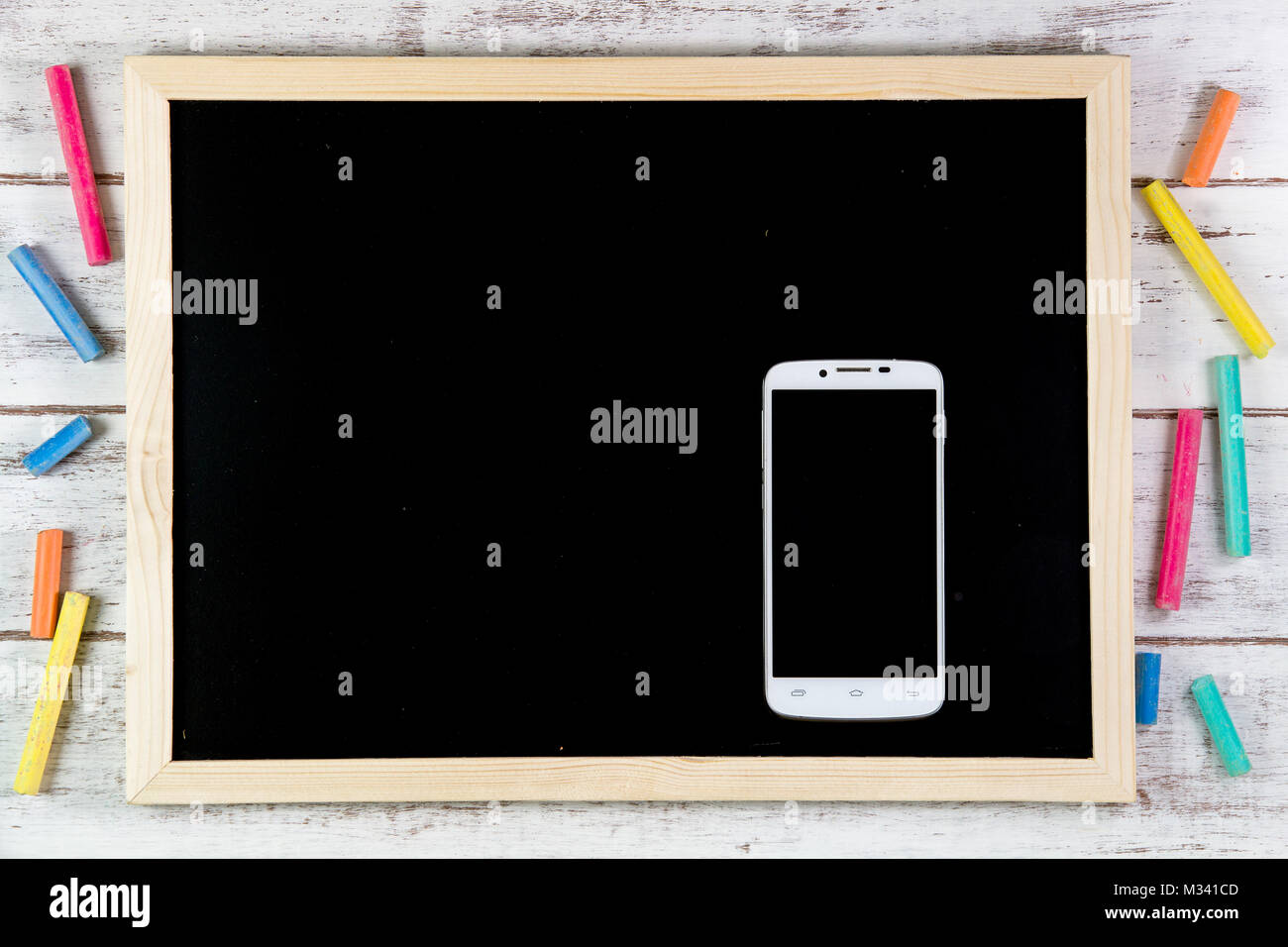 Blank blackboard and smart phone on wooden table.Template mock up for ...